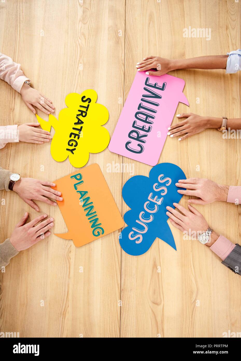 overhead view of multiracial business people at wooden table with ...
