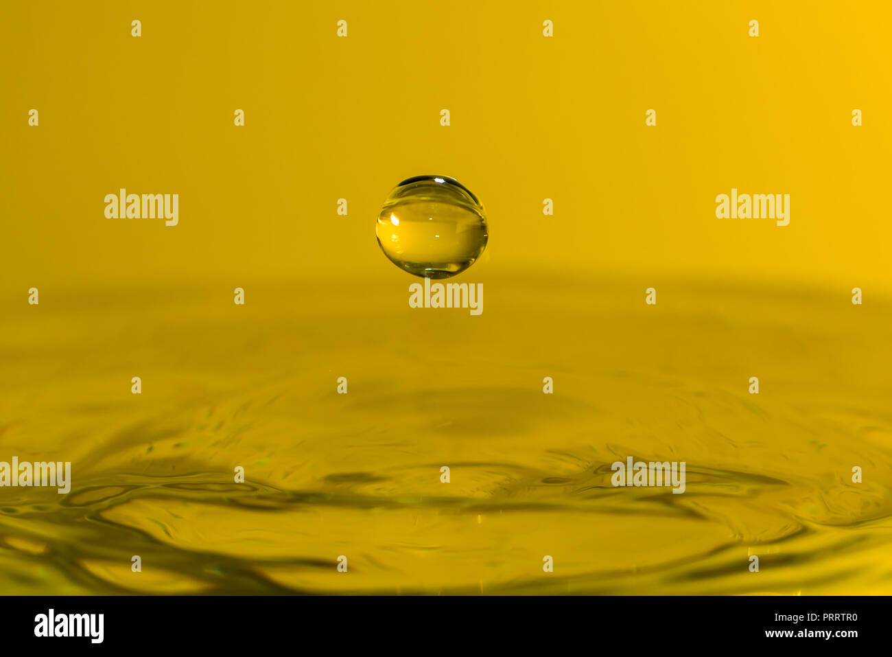 Colorful water droplet bouncing on water Stock Photo - Alamy