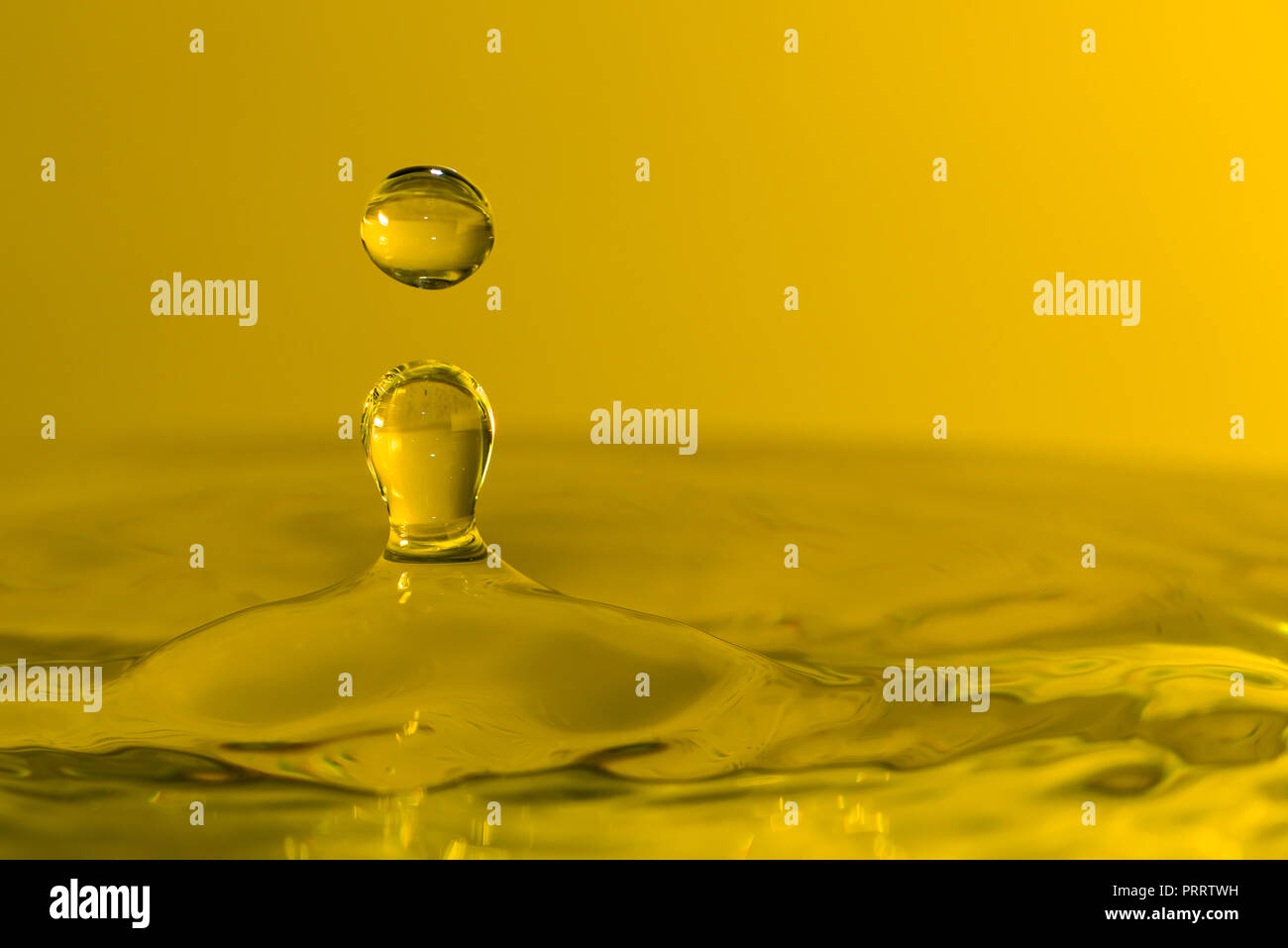 Colorful water droplet bouncing on water Stock Photo - Alamy