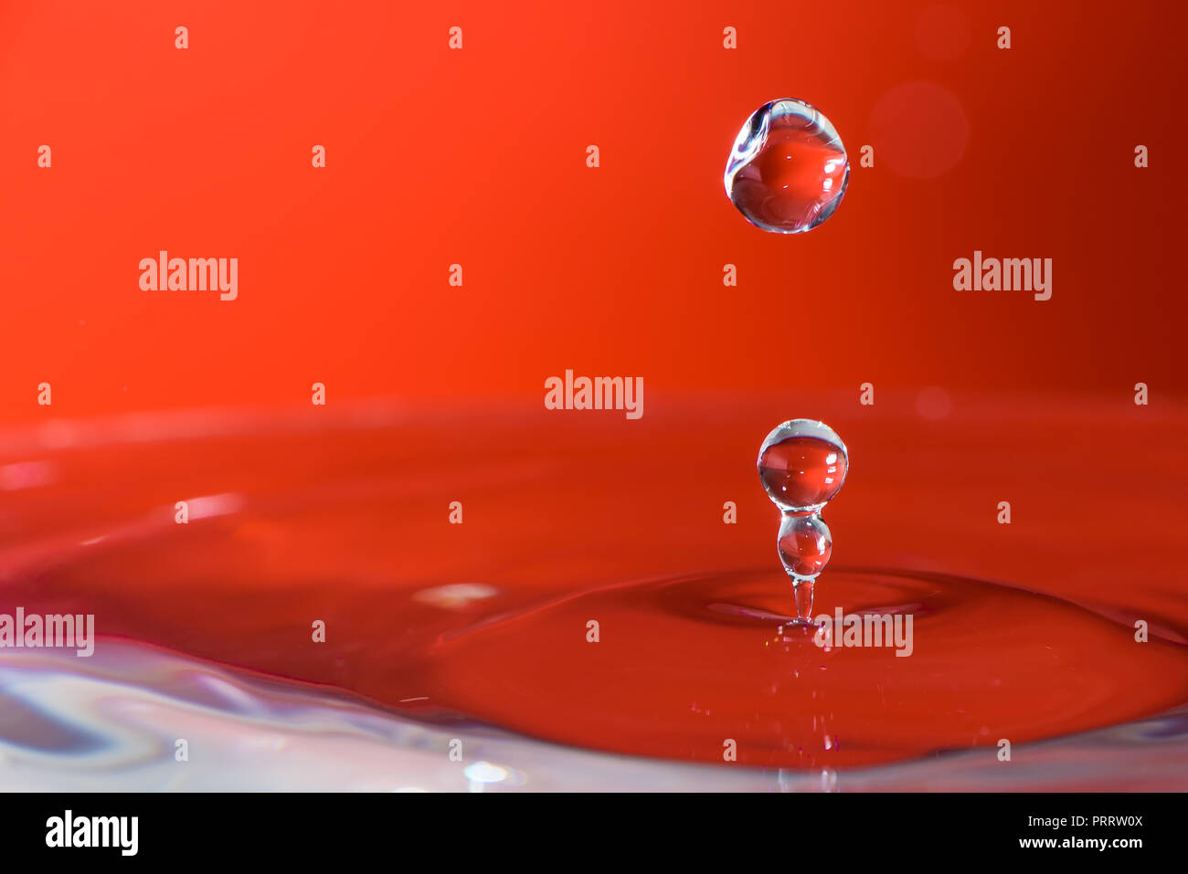 Colorful water droplet bouncing on water Stock Photo - Alamy