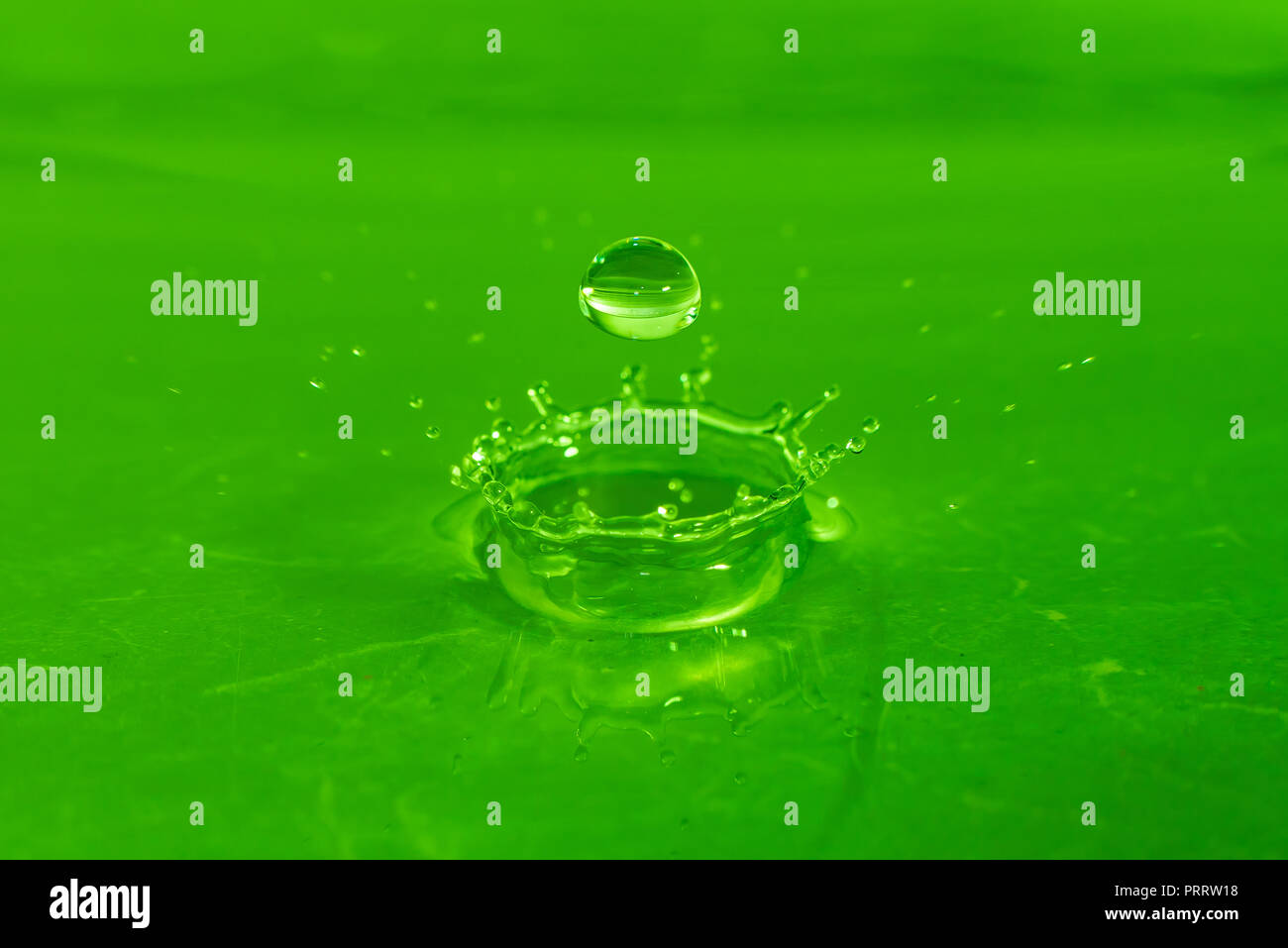 Colorful water droplet bouncing on water Stock Photo - Alamy