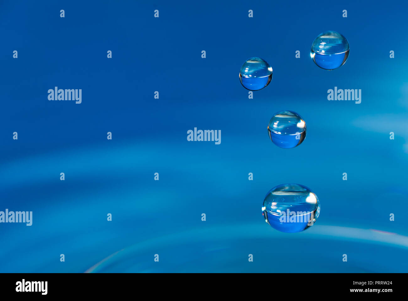 Colorful water droplet bouncing on water Stock Photo - Alamy