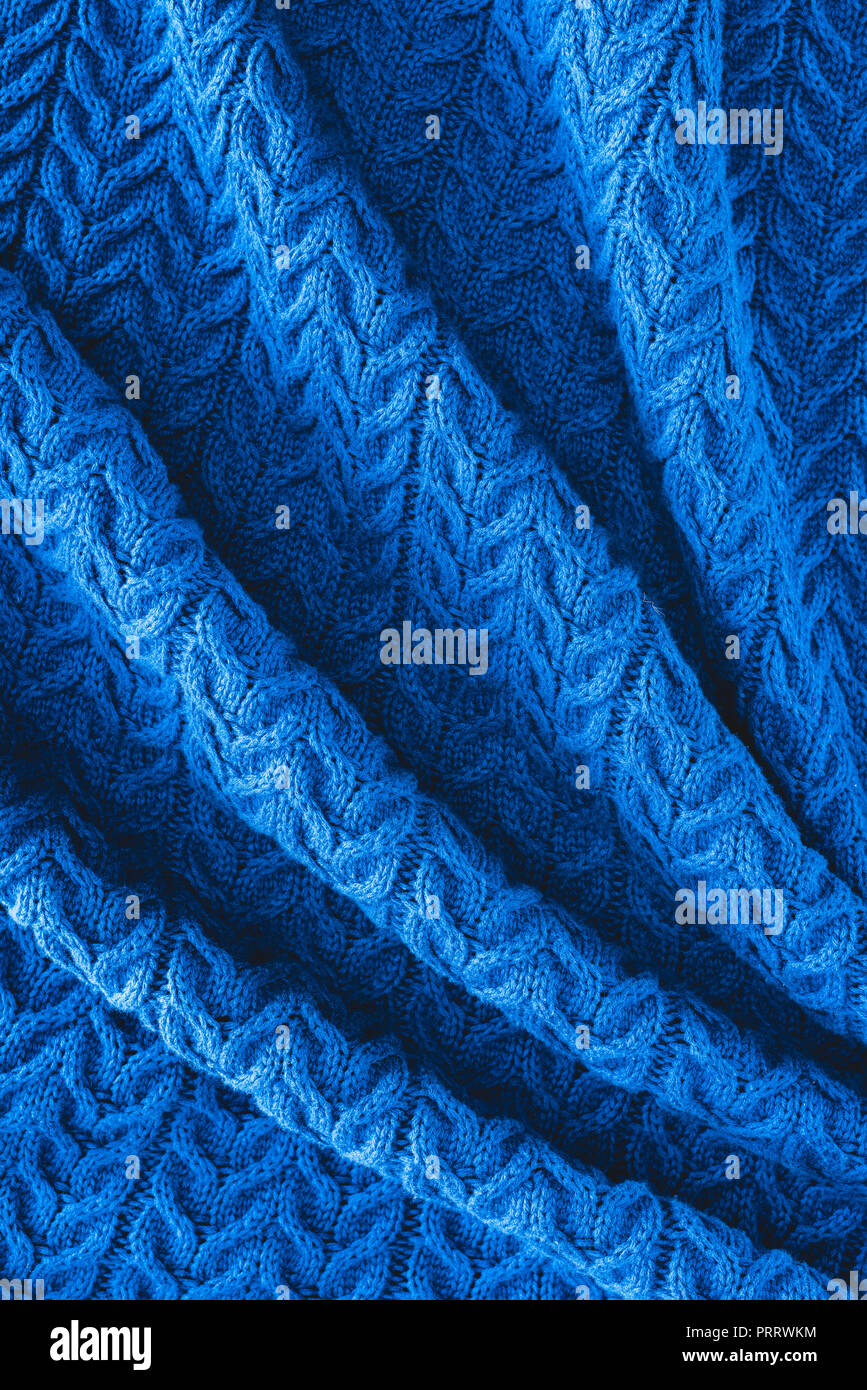 full frame of folded dark blue woolen fabric with pattern as backdrop ...