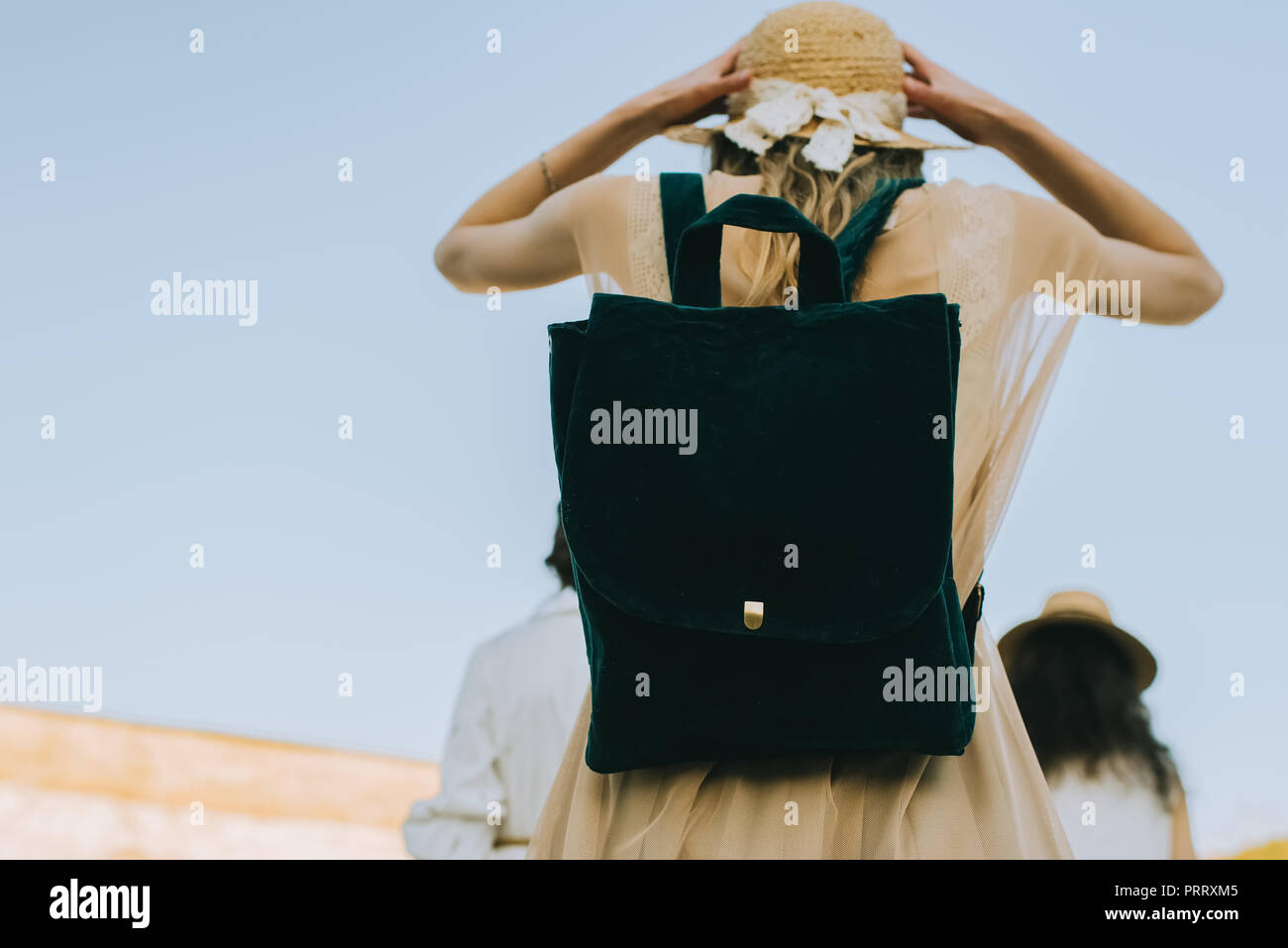 back view of girl in straw hat with black backpack Stock Photo - Alamy