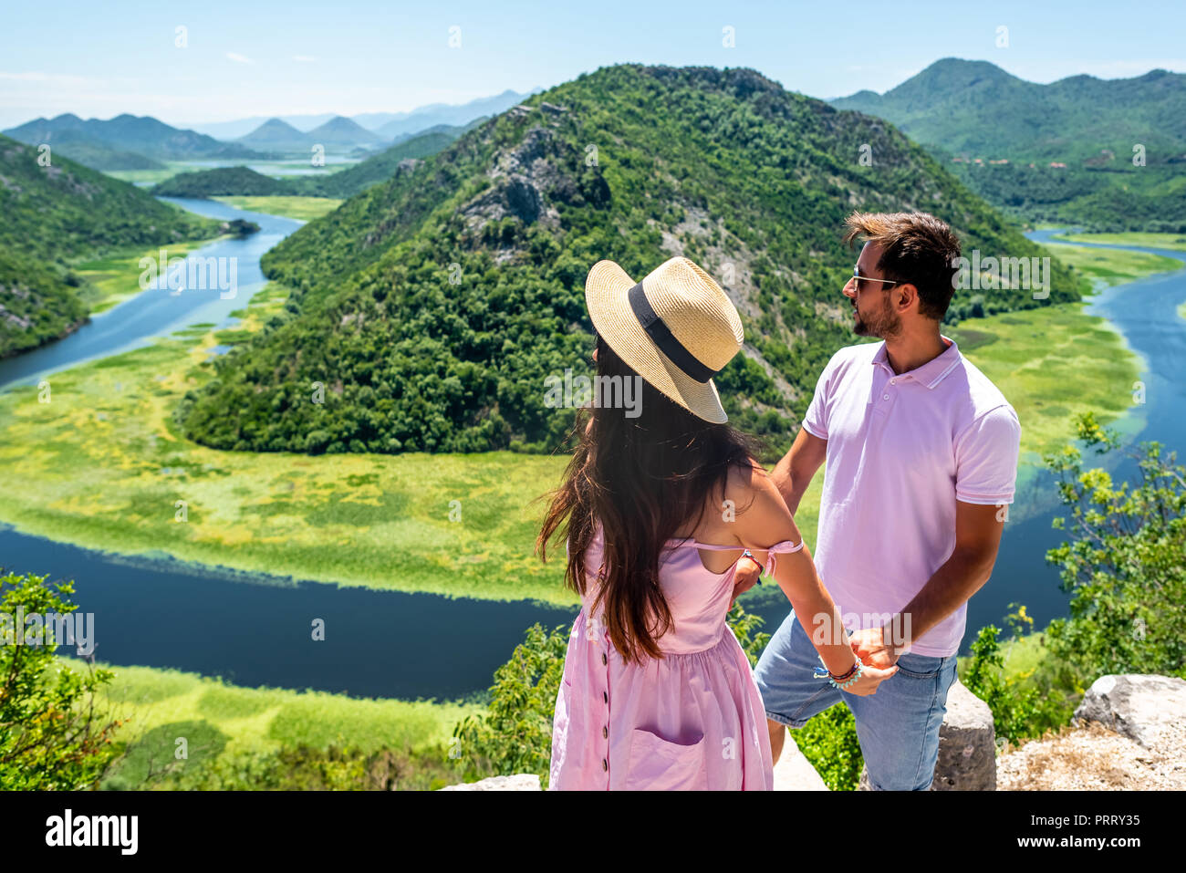 couple in pink clothes holding hands and looking at Crnojevica River in Montenegro Stock Photo ...