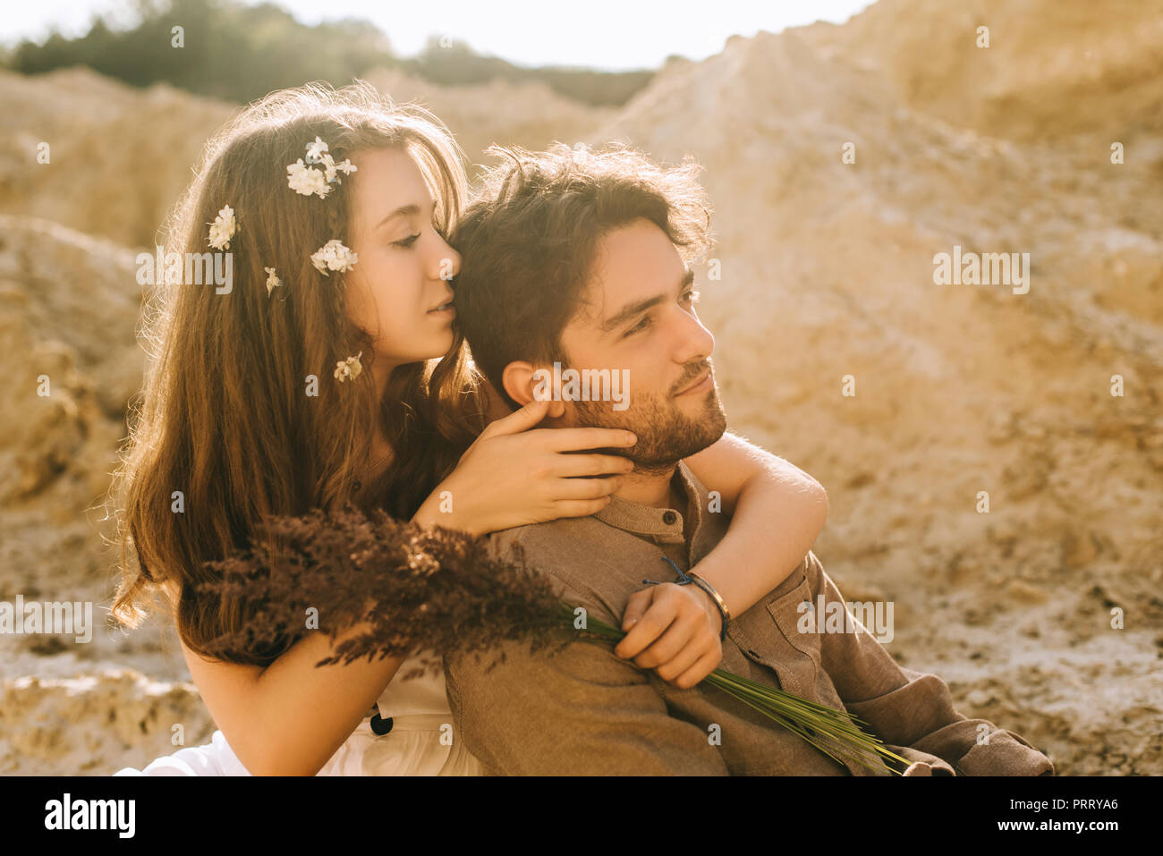 beautiful girl with flowers in hair hugging her boyfriend and holding ...