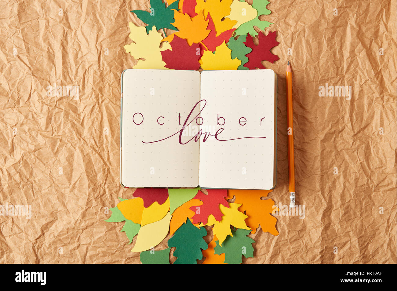 top view of notebook with "october love" lettering, pencil and colorful ...