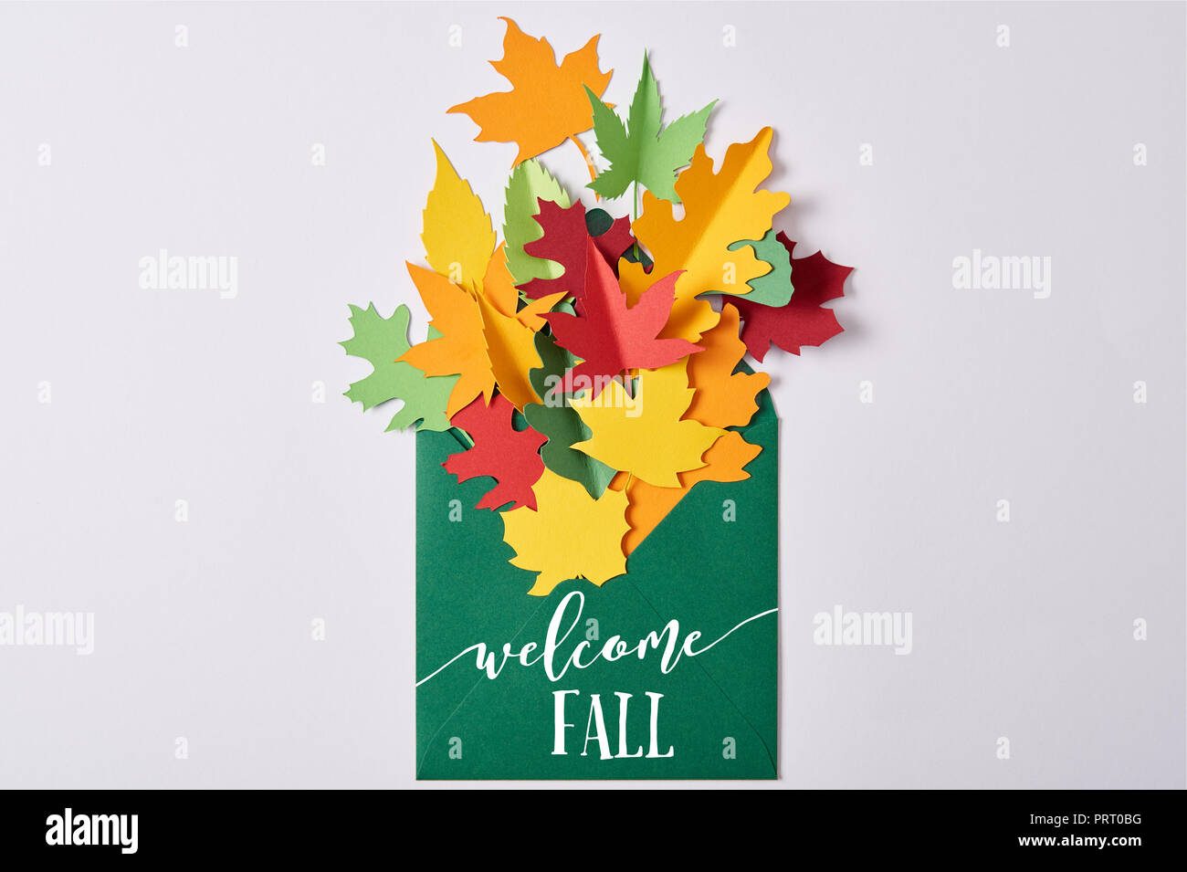 top view of colorful handcrafted paper leaves in green envelope with ...