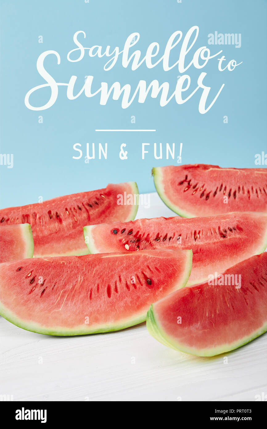 red watermelon slices on white surface on blue backdrop, with "say ...