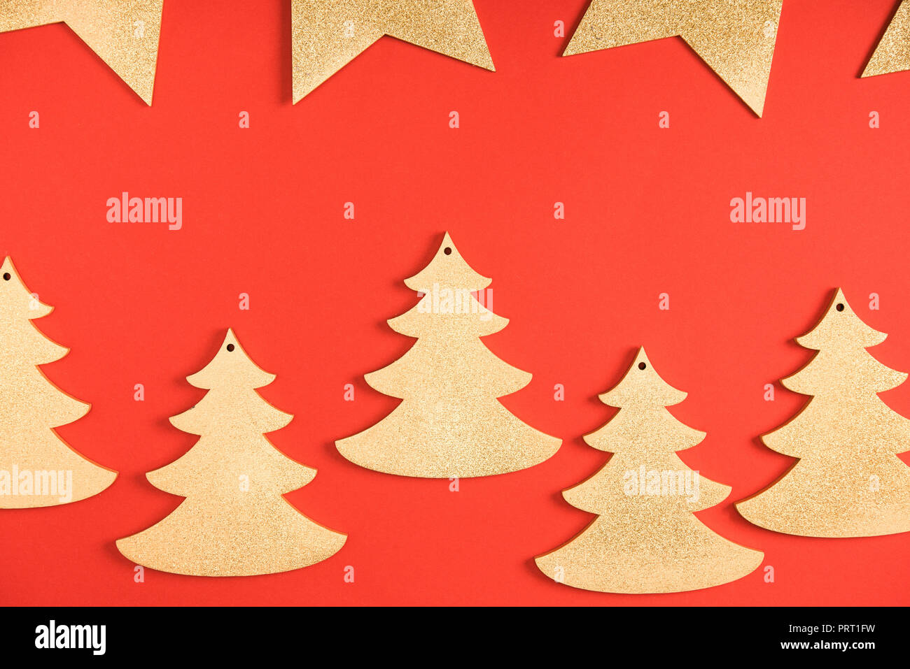 top view of golden stars and fir trees symbols on red background Stock ...