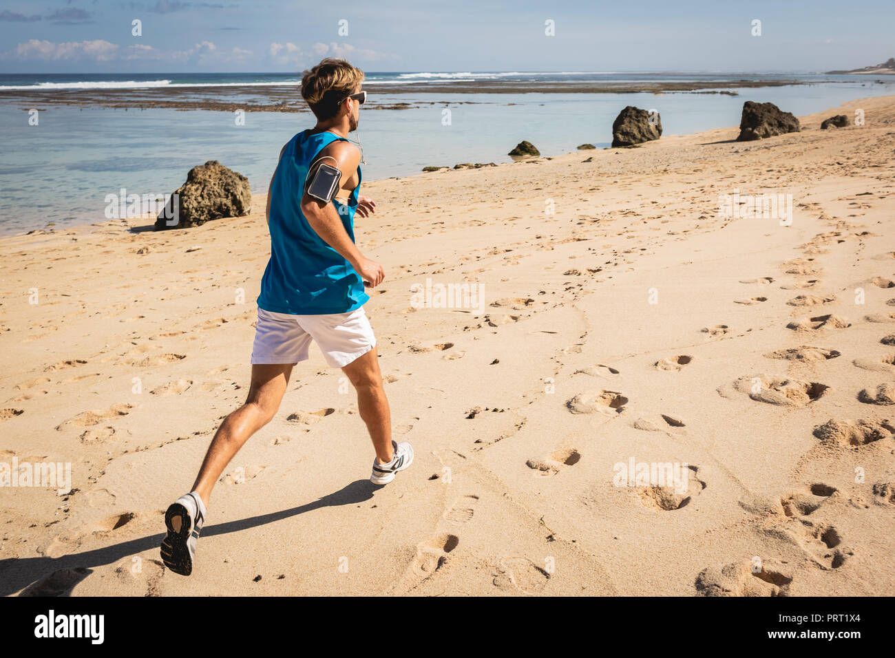runner working out on sand beach near sea, Bali, Indonesia Stock Photo ...