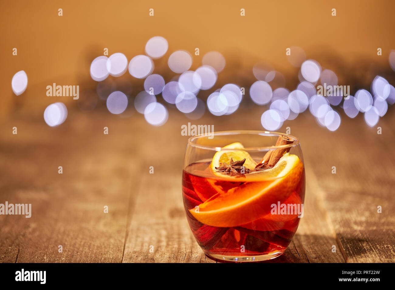 close up view of mulled wine drink with orange pieces and anise stars ...