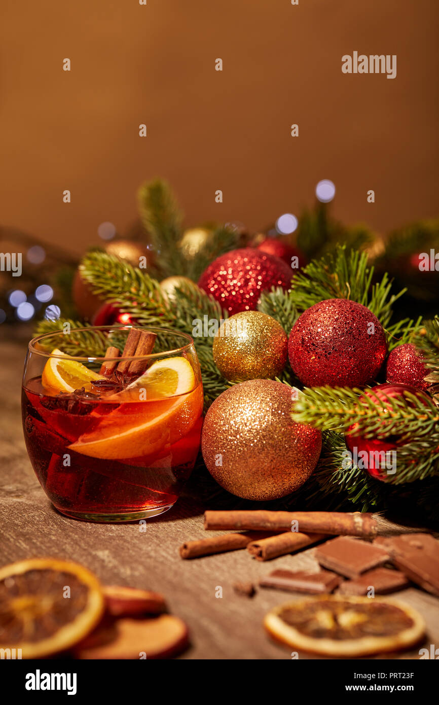 close up view of mulled wine drink in glass and pine tree with ...