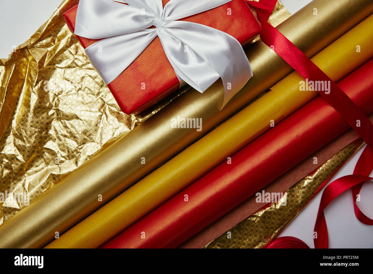 top view of present with ribbon and bright wrapping papers on white ...