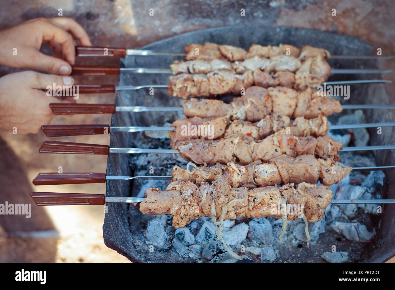 Raw meat is fried at the stake. Male fry the kebabs on grill Stock ...