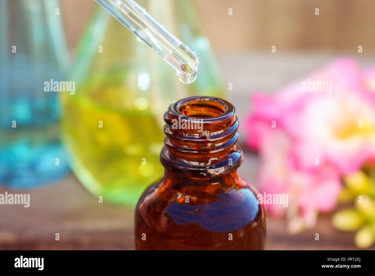 drop of oil dripping from pipette into bottles of essential oil Stock ...