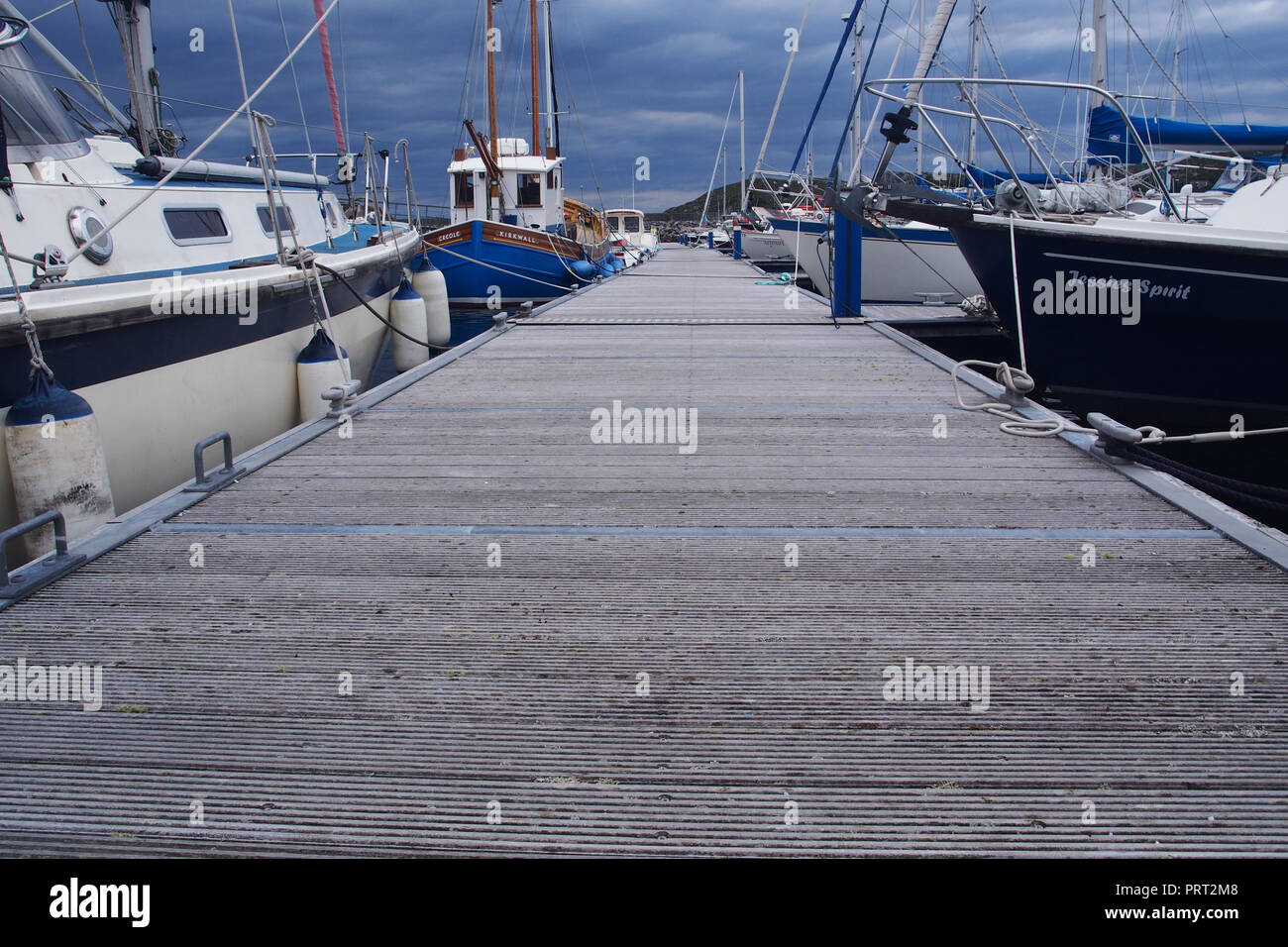 A view along a floating walkway at Lochinver harbour, Scotland with ...