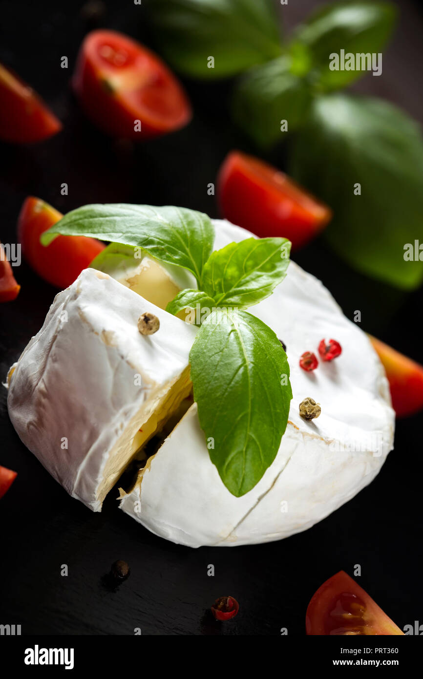 Camembert cheese with basil leaves four colors pepper and chili peppers ...
