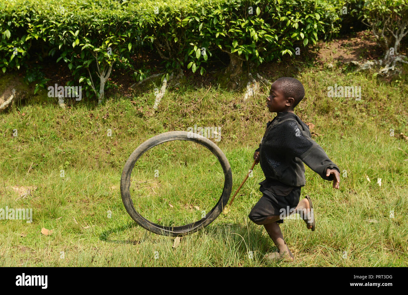 A Rwandan boy playing with a bicycle tire in rural Rwanda Stock Photo ...