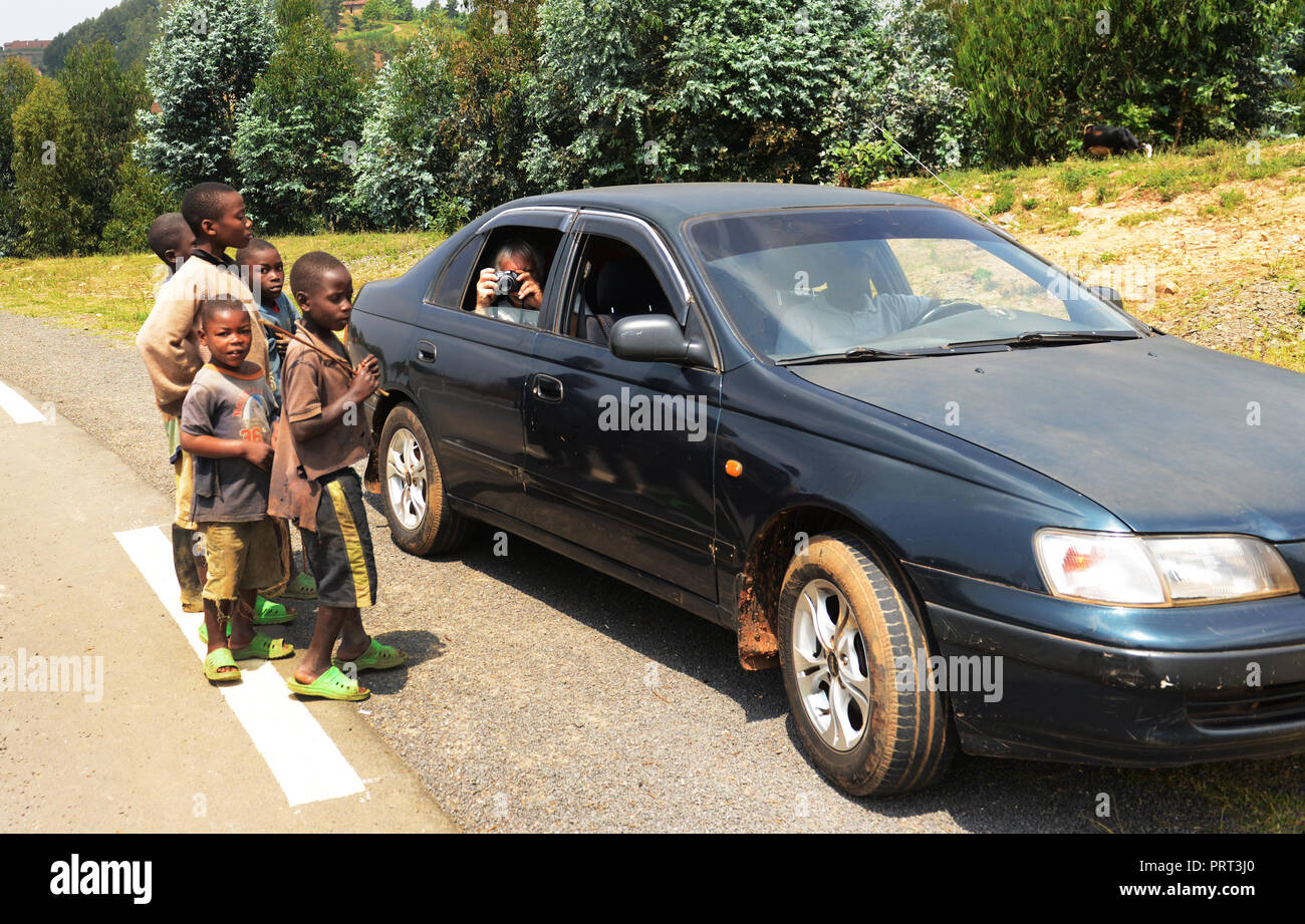 Rwandan children checking a tourist in his car in rural western Rwanda ...