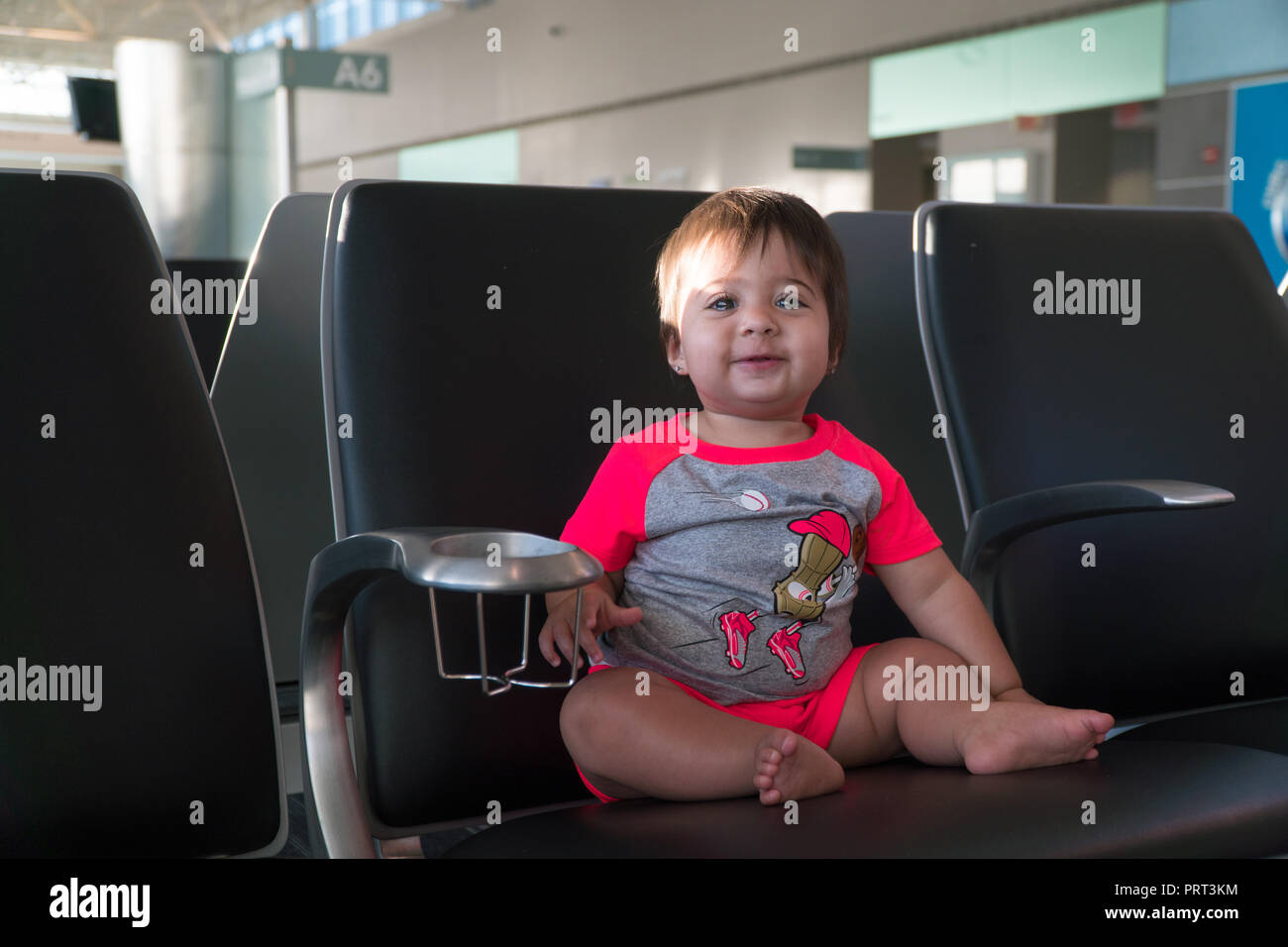 Adorable young happy cute baby girl alone in airport terminal gate ...