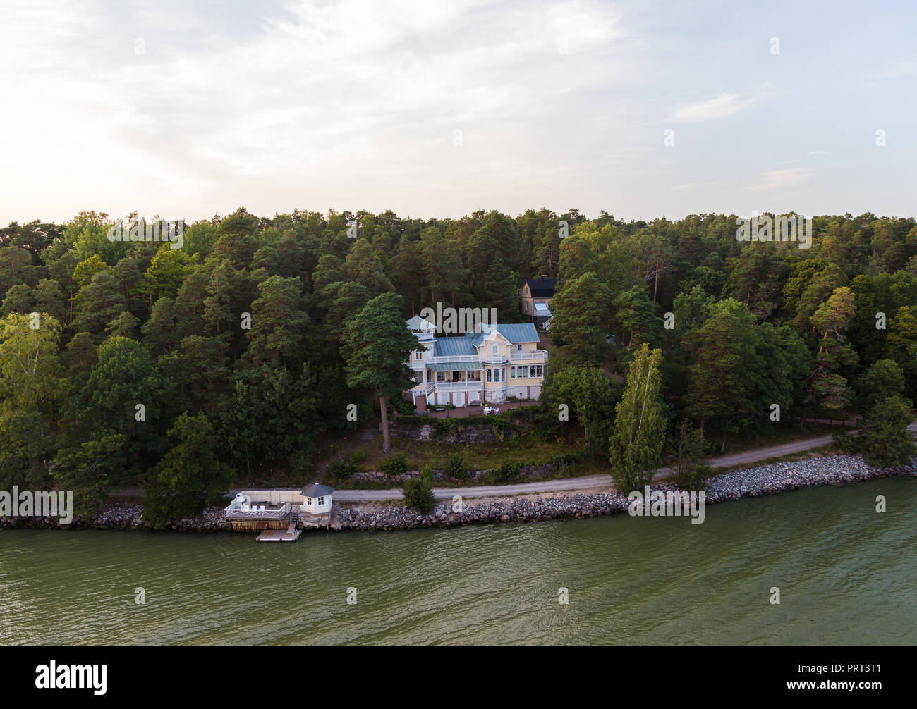 Wooden big house in the Turku archipelago with a pier at the water ...