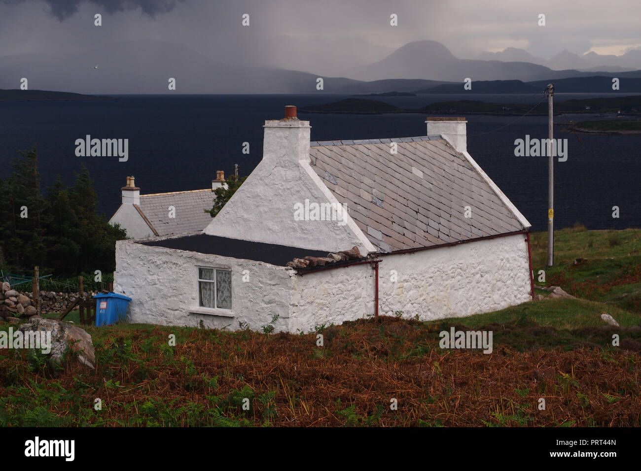 A view of a small white croft house in Polbain, Scotland with the ...