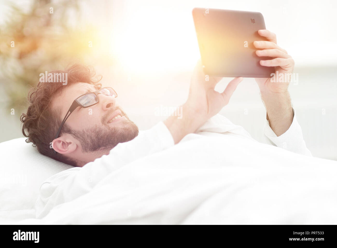 closeup.sleepy man looking at the screen of a digital tablet Stock ...