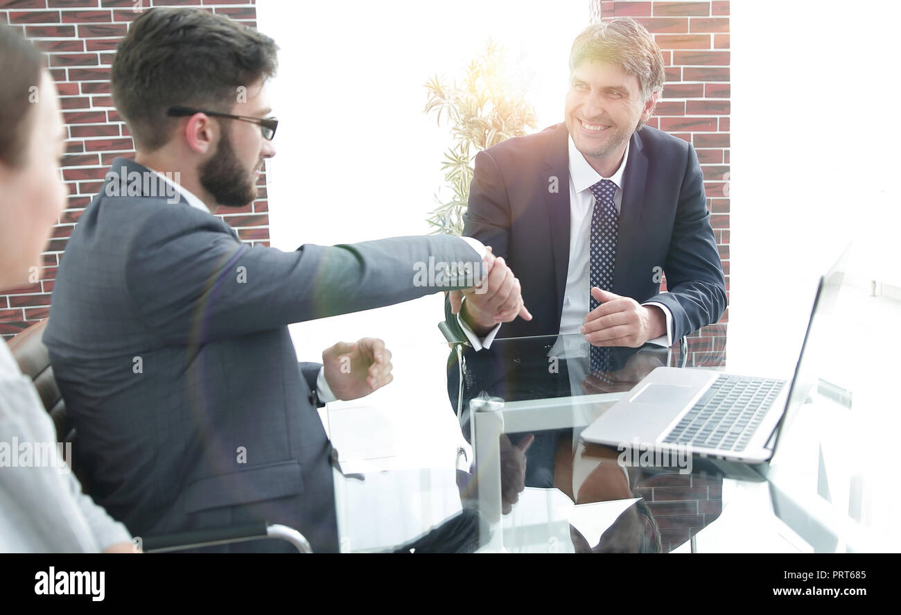 Handshake of businessmen at the desk Stock Photo - Alamy