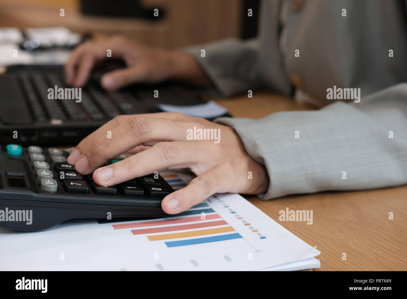 financial adviser working with calculator & computer at office ...