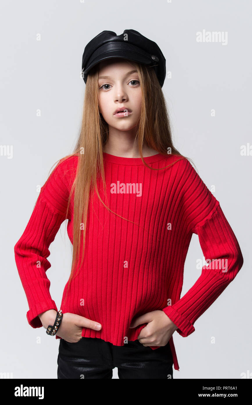 Close-up portrait of beautiful young redhead girl wearing red sweater ...