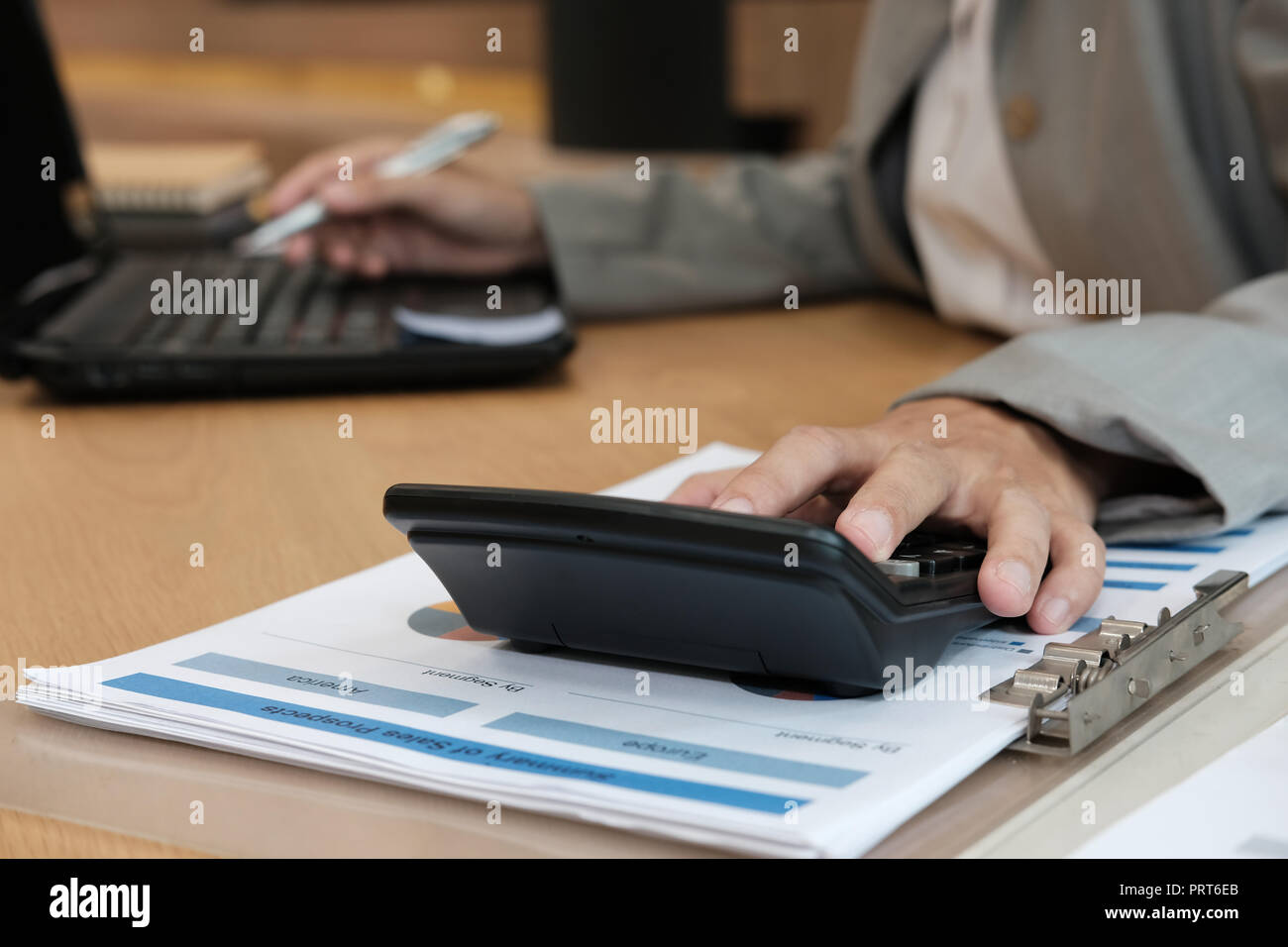 financial adviser working with calculator & computer at office ...
