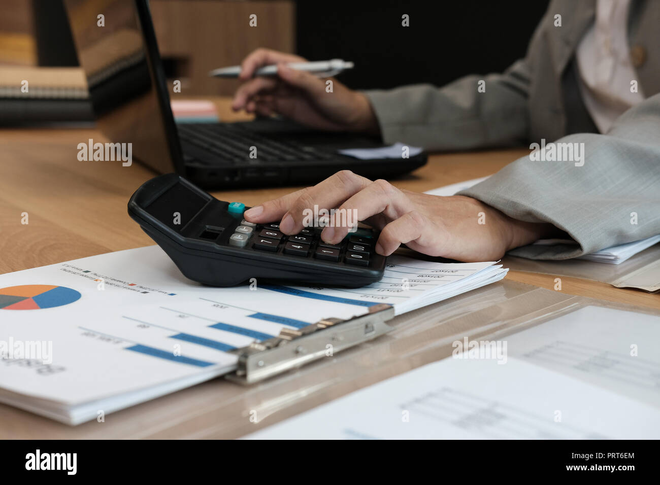 financial adviser working with calculator & computer at office ...