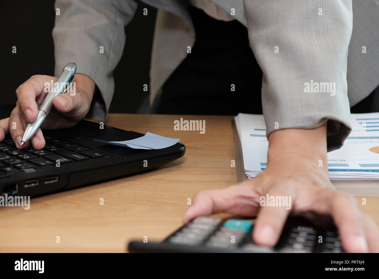 financial adviser working with calculator & computer at office ...