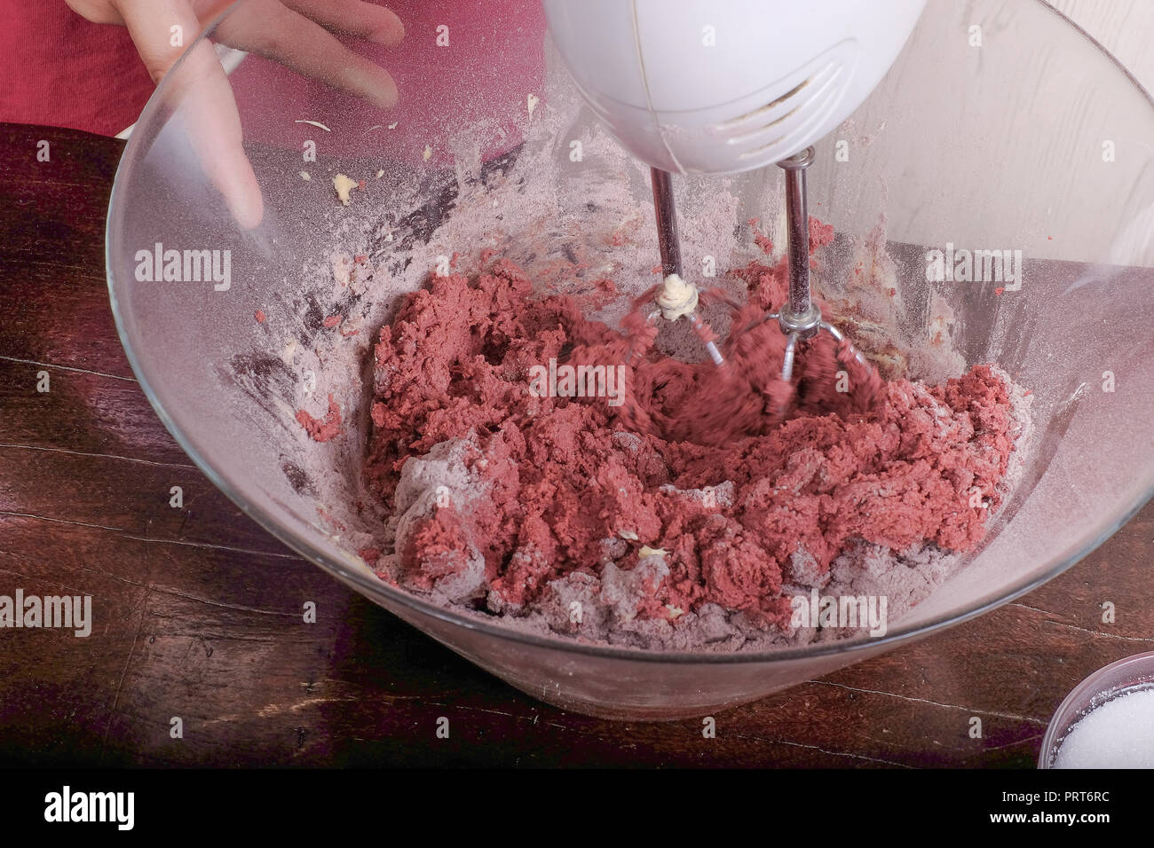 Happy boy mixing ingradients in the glass bowl and preparing a red ...