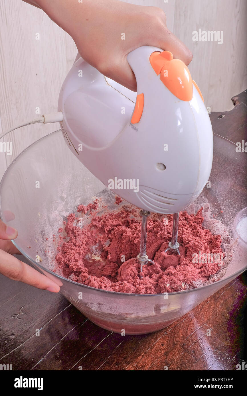 Happy boy mixing ingradients in the glass bowl and preparing a red ...