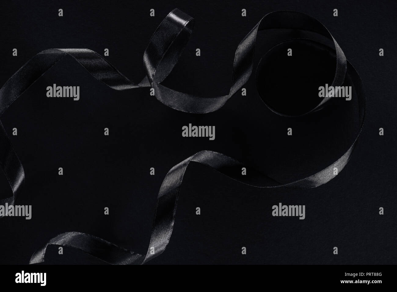 top view of black glossy ribbon on black background Stock Photo - Alamy