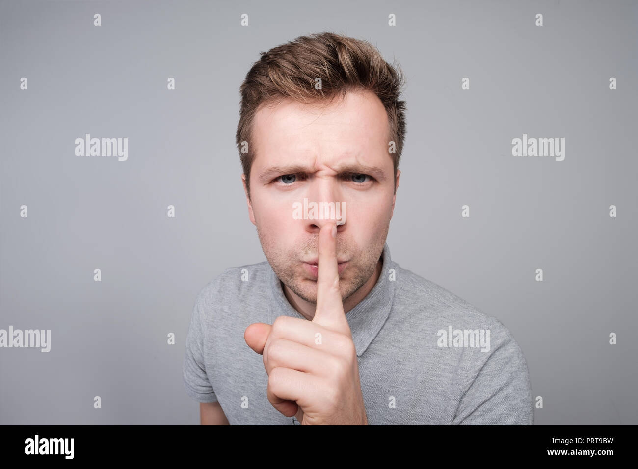 Man finger mouth saying quiet hi-res stock photography and images - Alamy