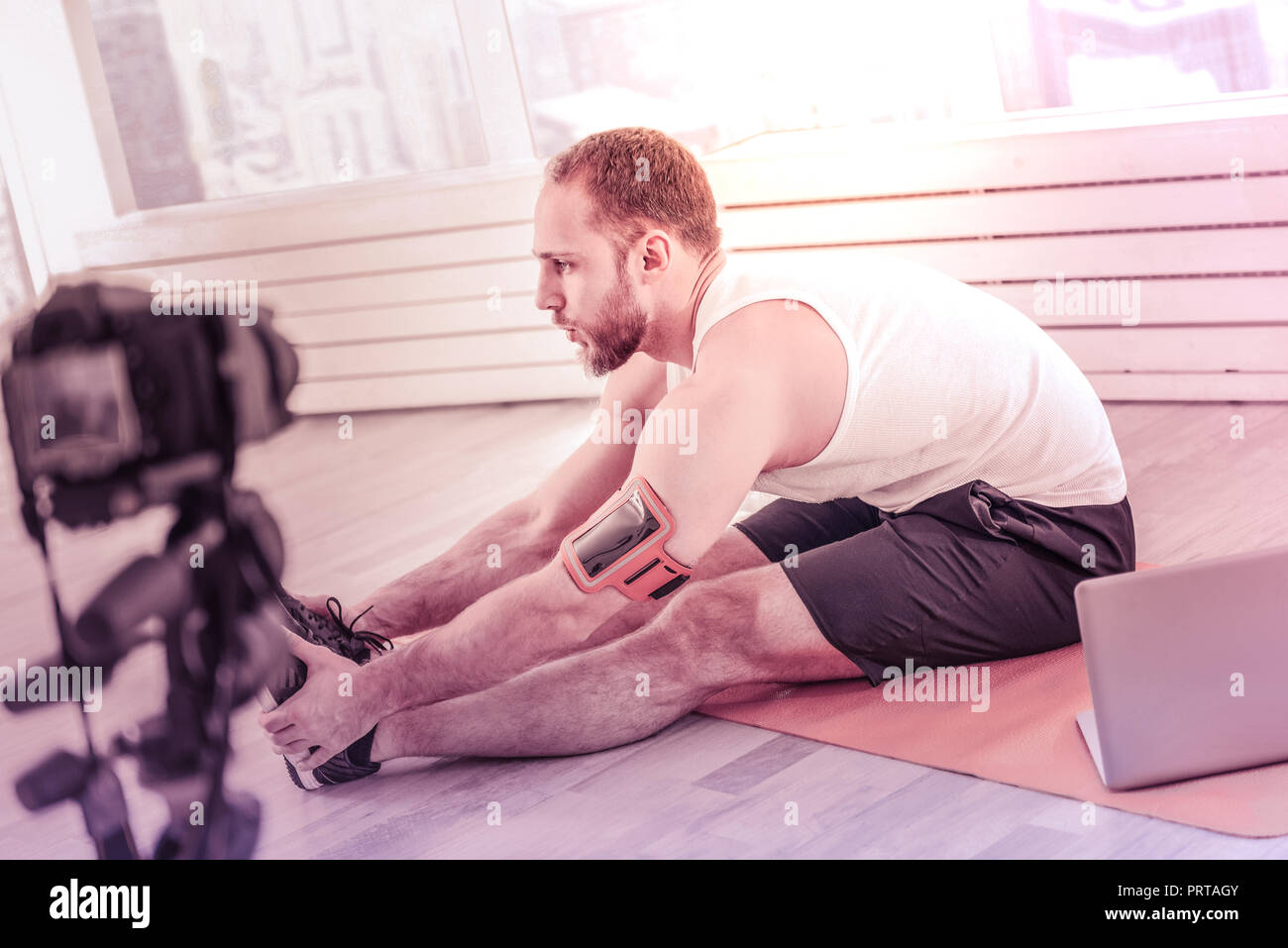 Concentrated skilled trainer doing morning exercises at home Stock ...