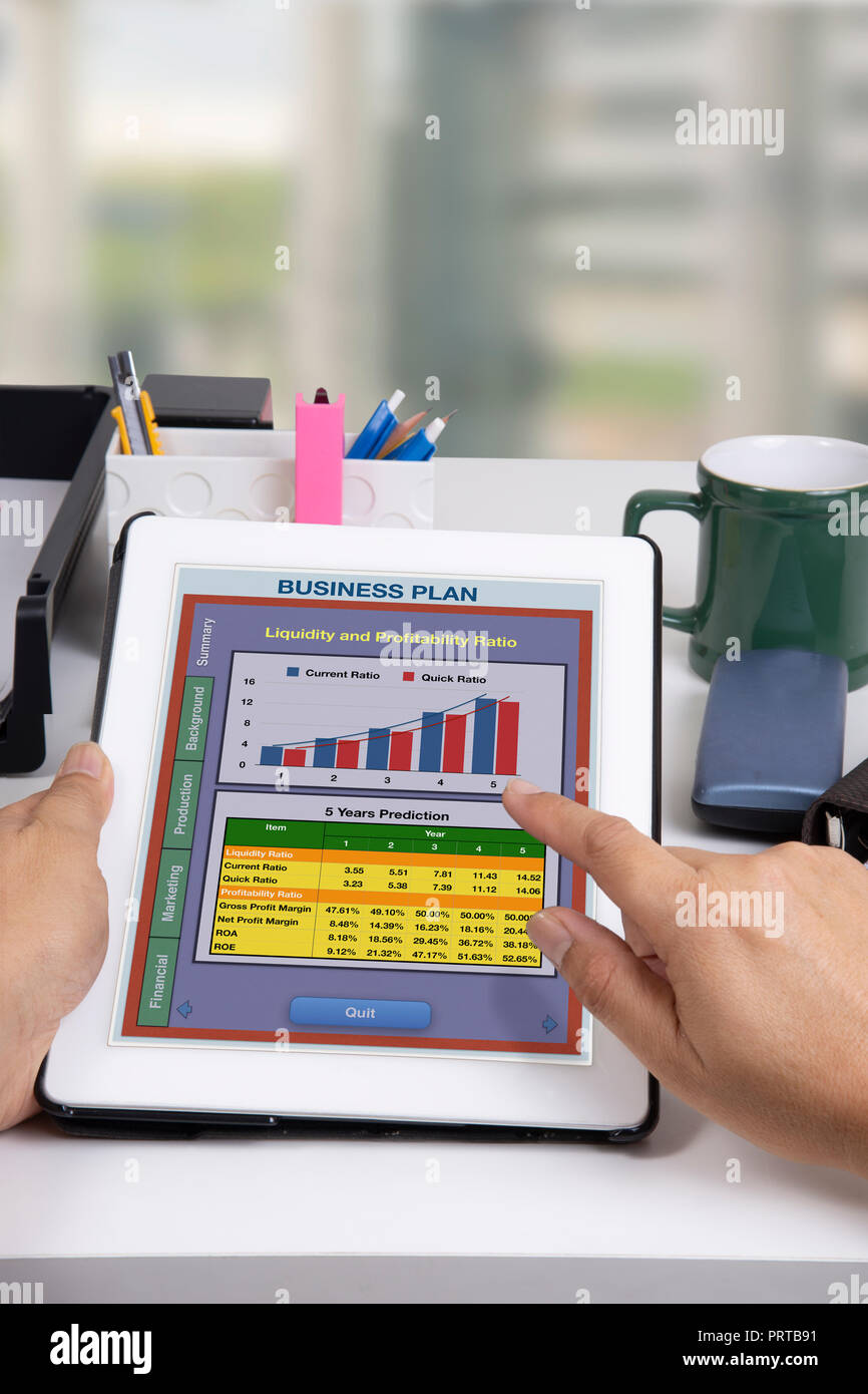 Someone working on business plan by using digital tablet on desk in ...