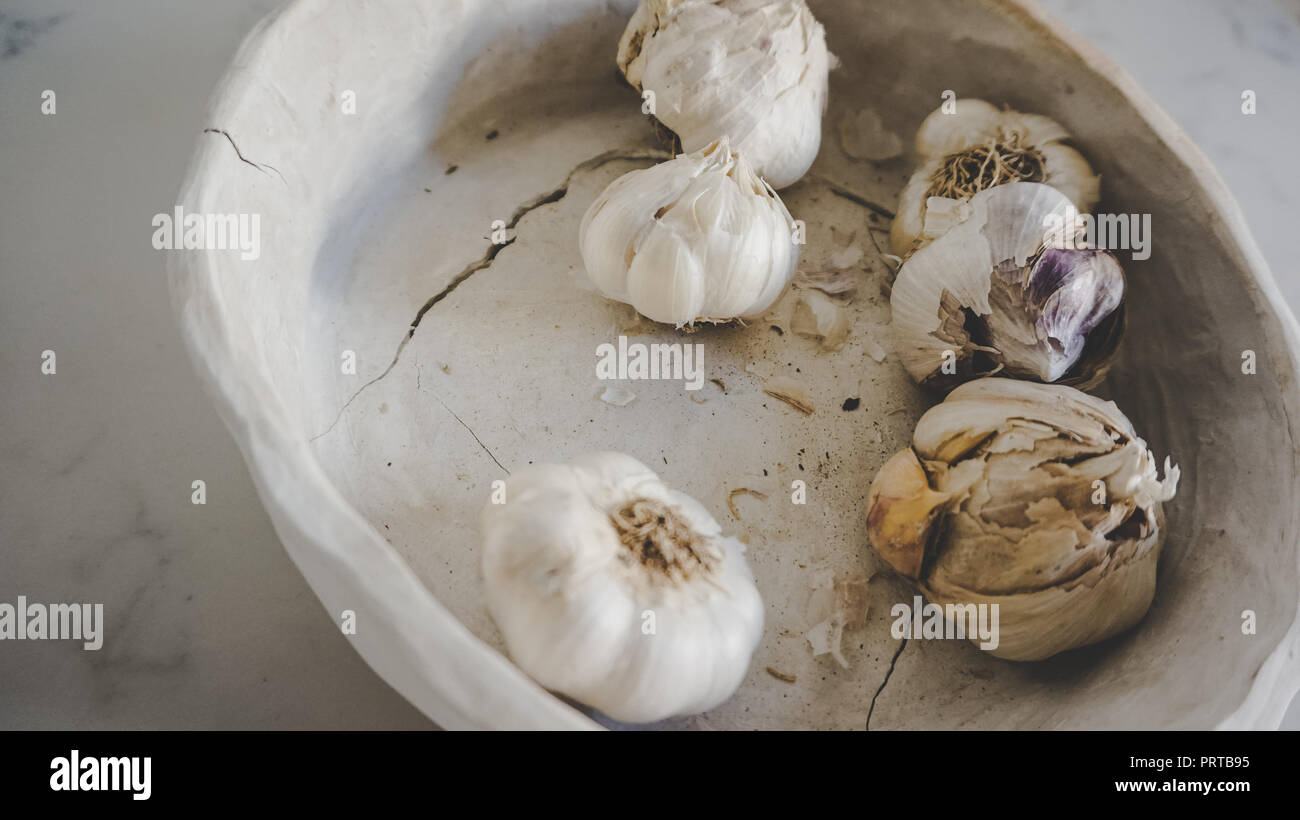 Rustic, white ceramic bowl of unpeeled garlic Stock Photo - Alamy