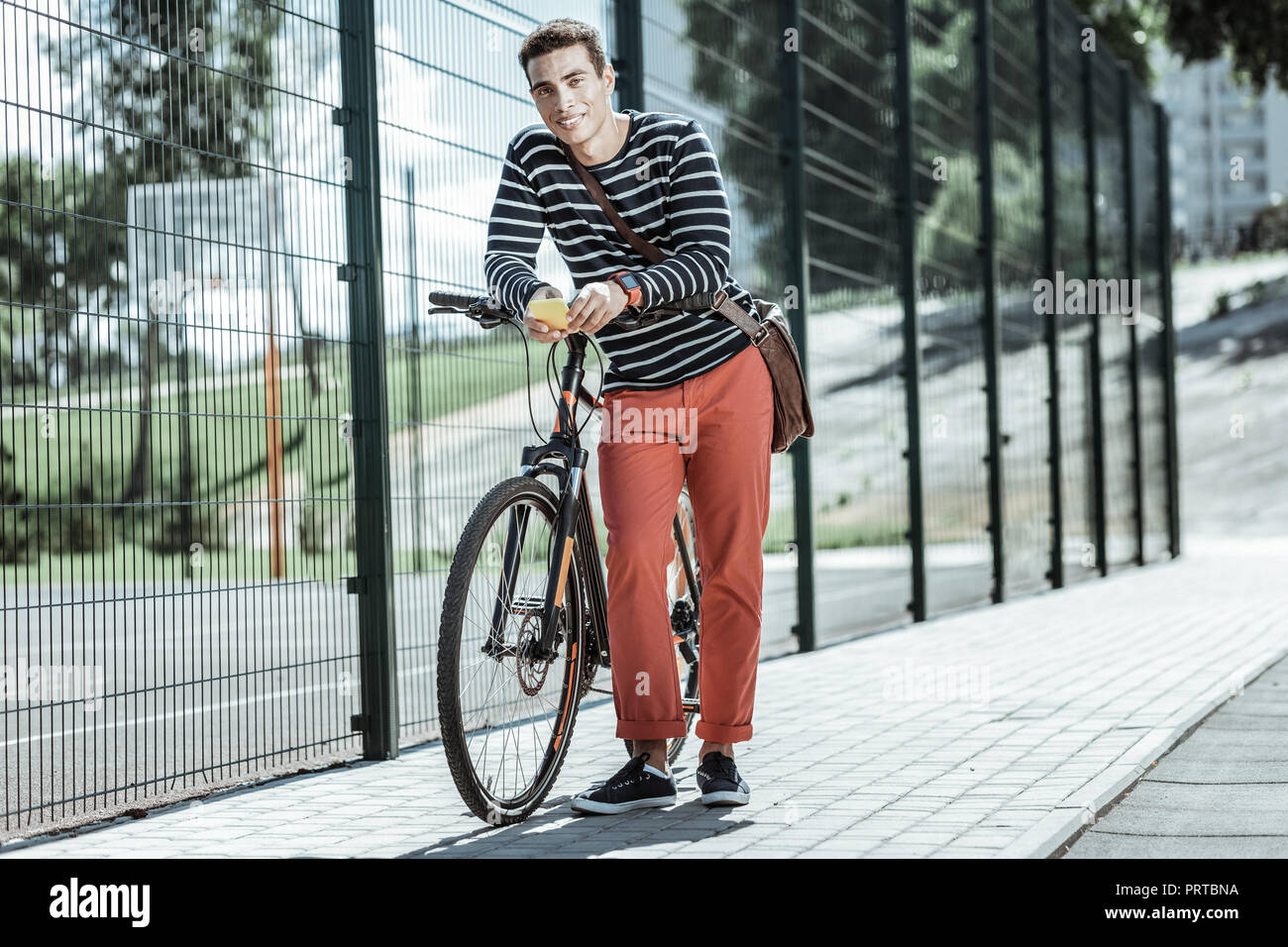 Handsome nice guy liking better bicycle than car Stock Photo - Alamy