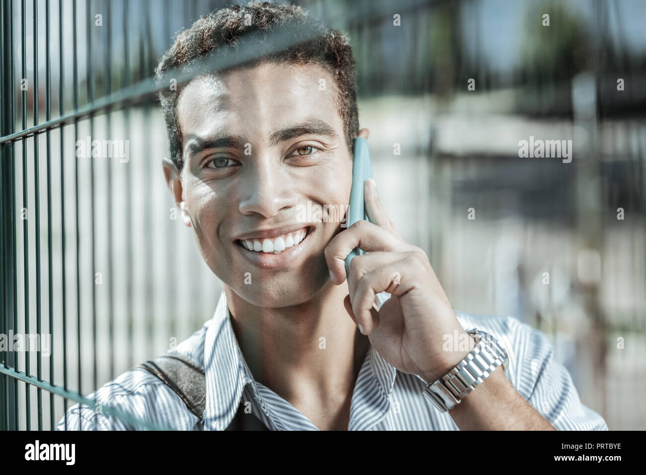 Happy optimistic guy making call on smartphone Stock Photo - Alamy