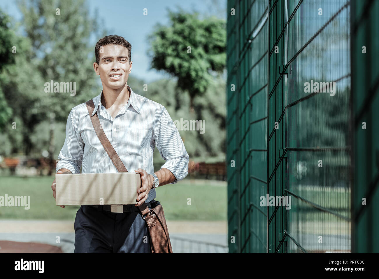 Serious male courier getting delivery in time Stock Photo - Alamy