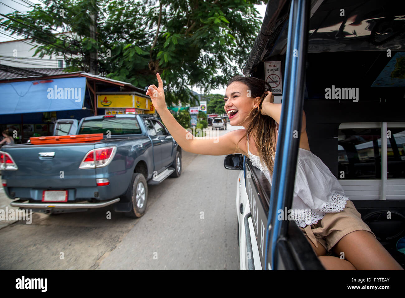 the girl with the emotions shows hand sign in a taxi travel concept ...