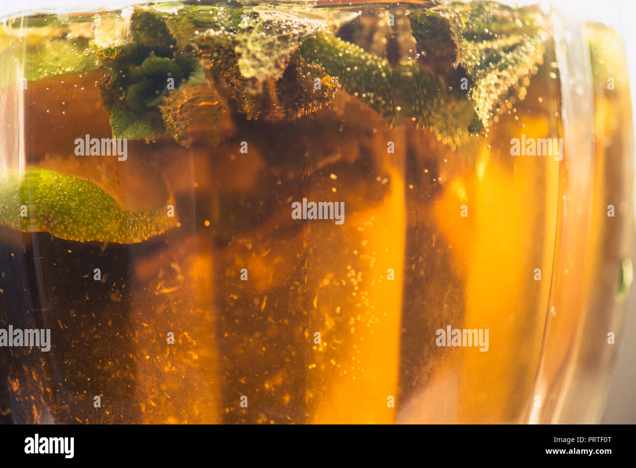Carbonated soda water or juice with lime and mint in a glass jug. Macro ...