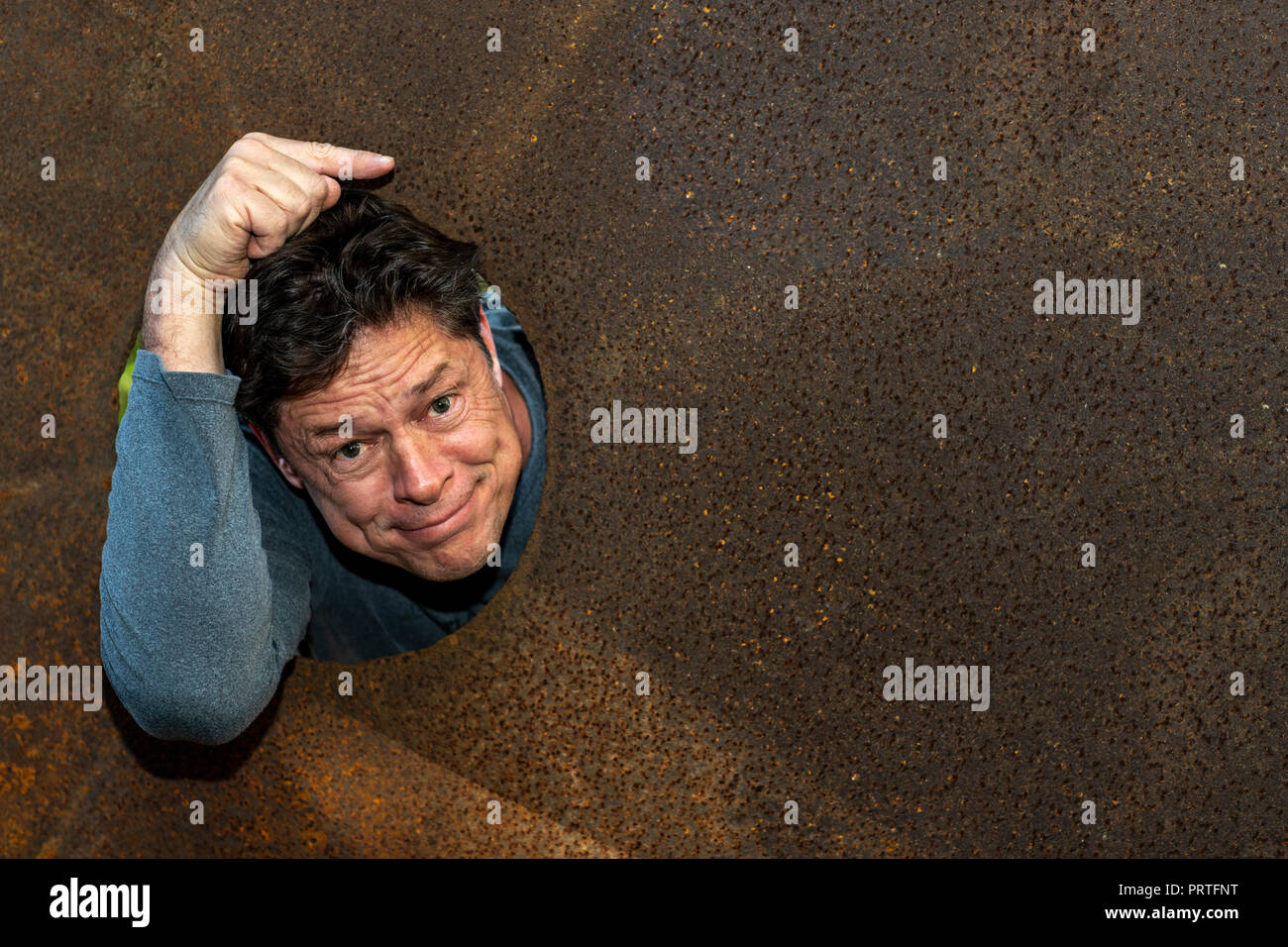 Lovely and happy man, inside brown iron plate, pointing a space for an ...