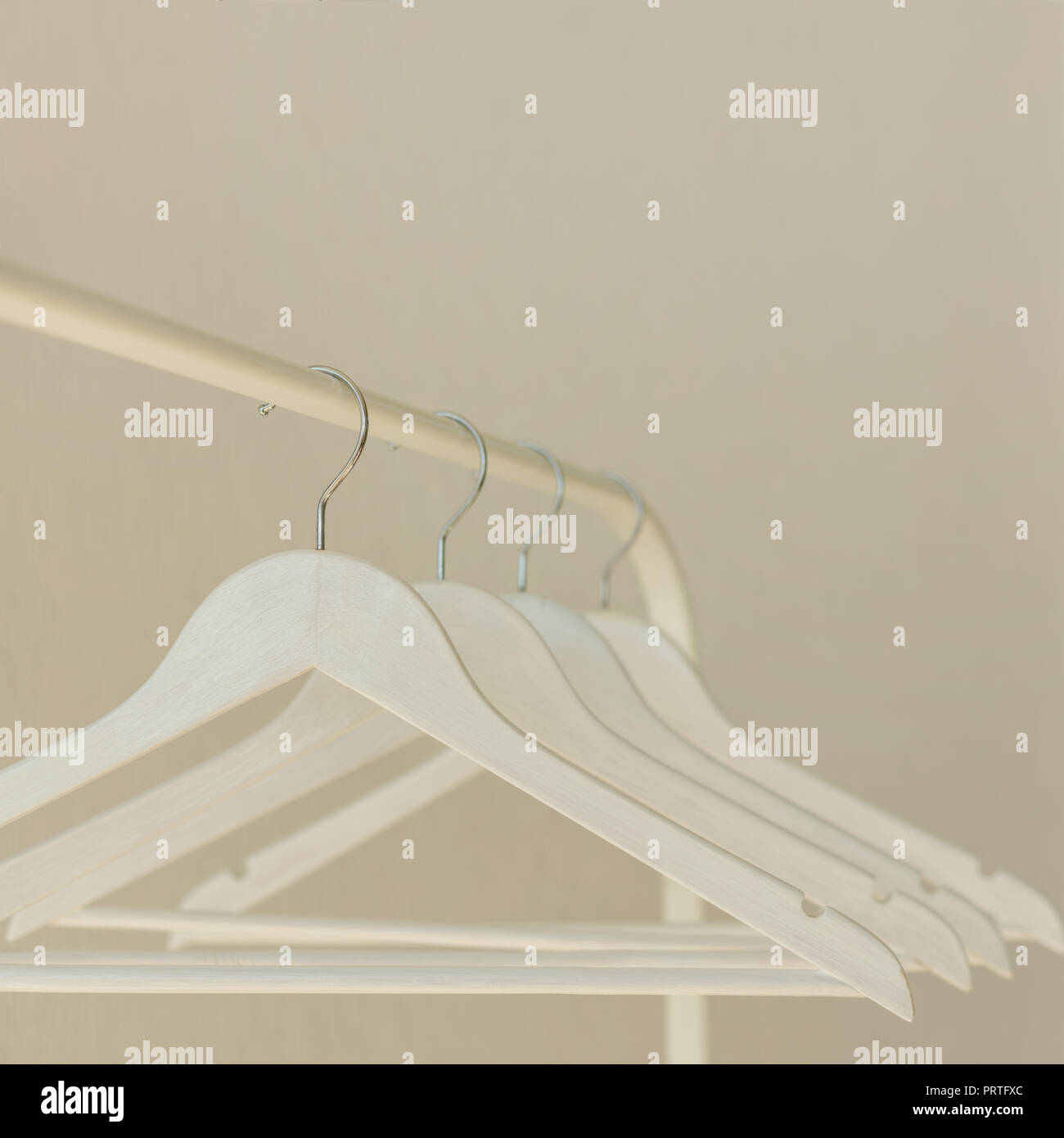 White row of hangers on the rack. Selective focus Stock Photo - Alamy