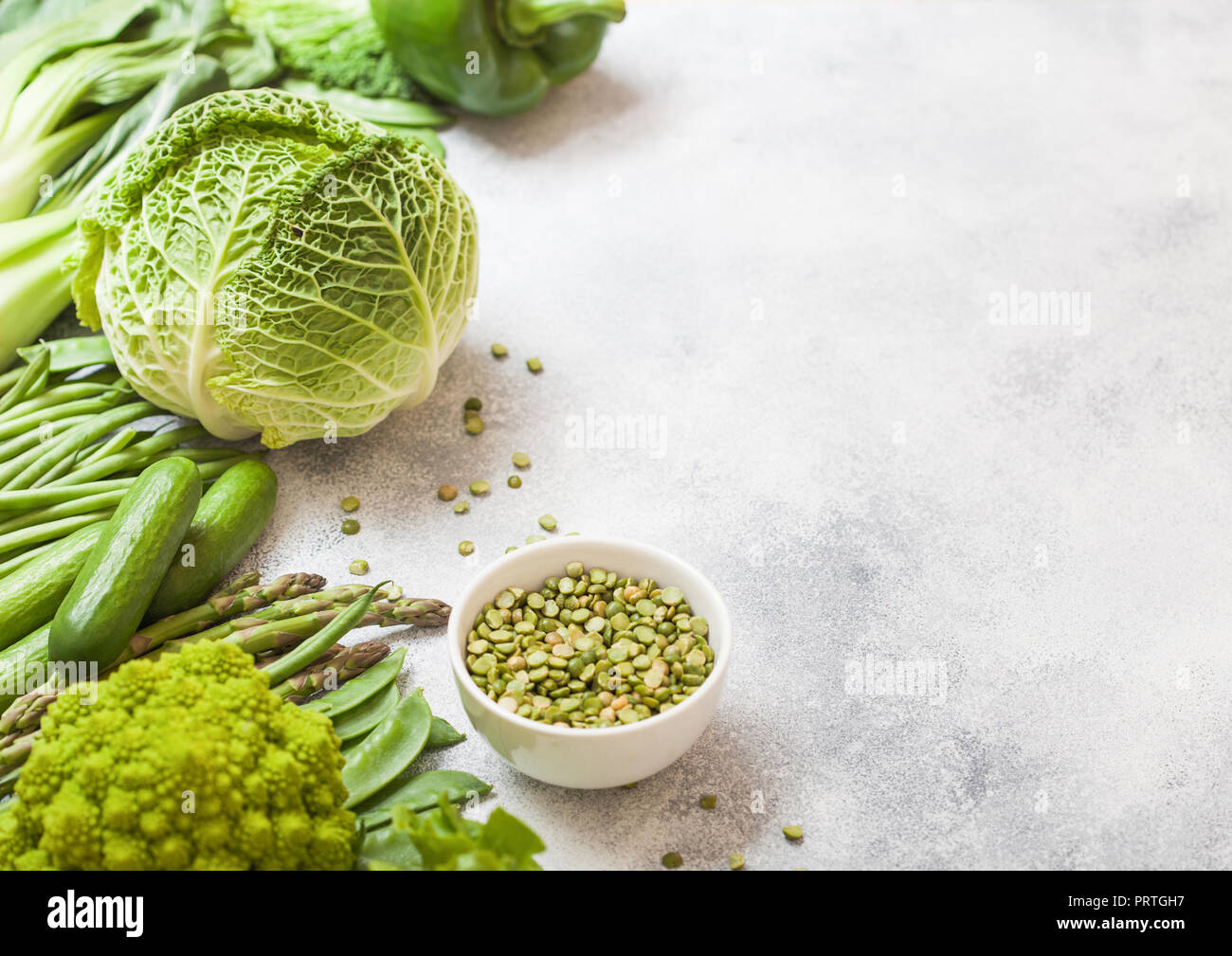 Assorted green toned raw organic vegetables on white background ...