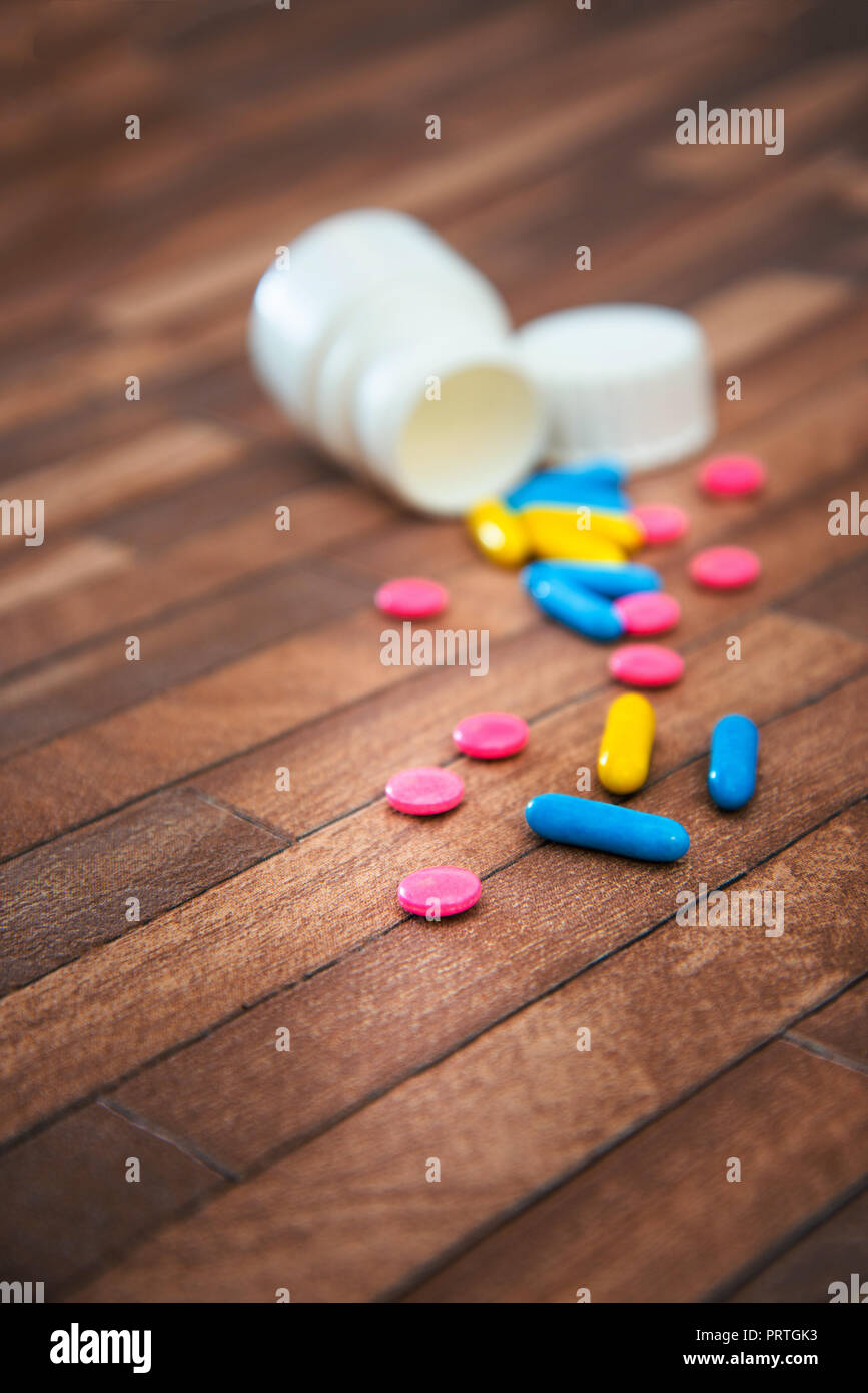 Health concept colorful medication and pills spilling out of a toppled ...
